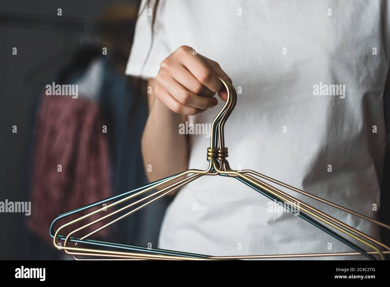 Woman holds metal clothes hangers in hands Stock Photo - Alamy