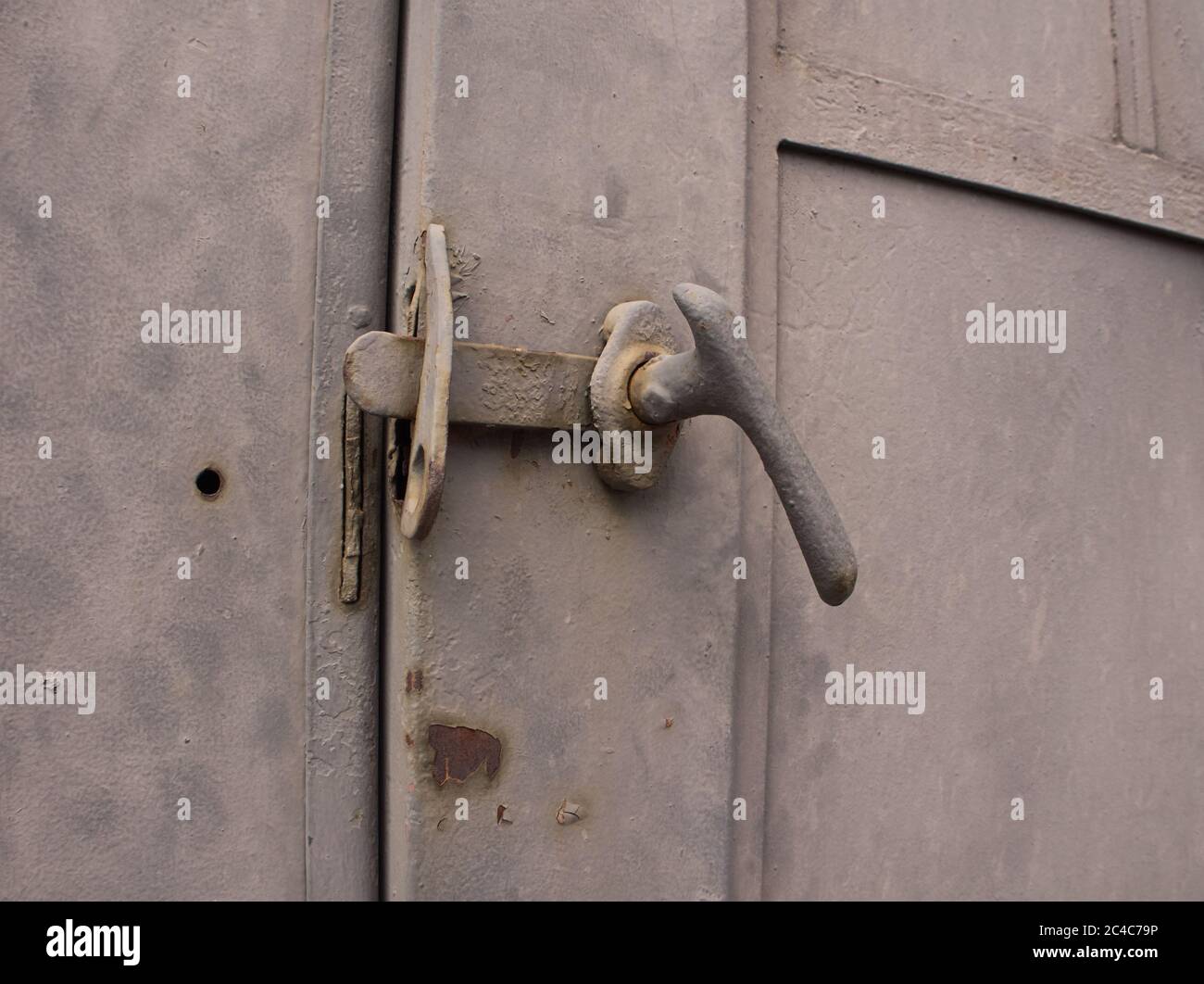 Door latch on and abandoned building grey door up close detail Stock ...