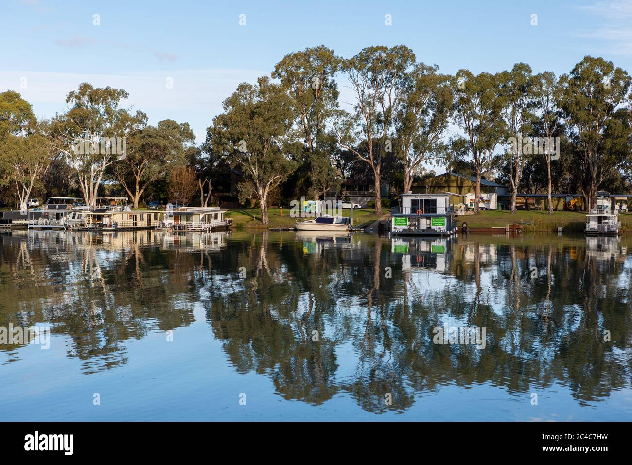 The reflection of house boats and tree on a calm river murray located ...
