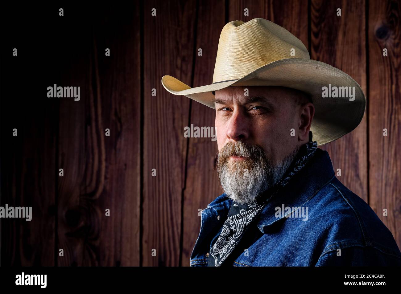 Older man with gray beard wearing a cowboy hat Stock Photo - Alamy