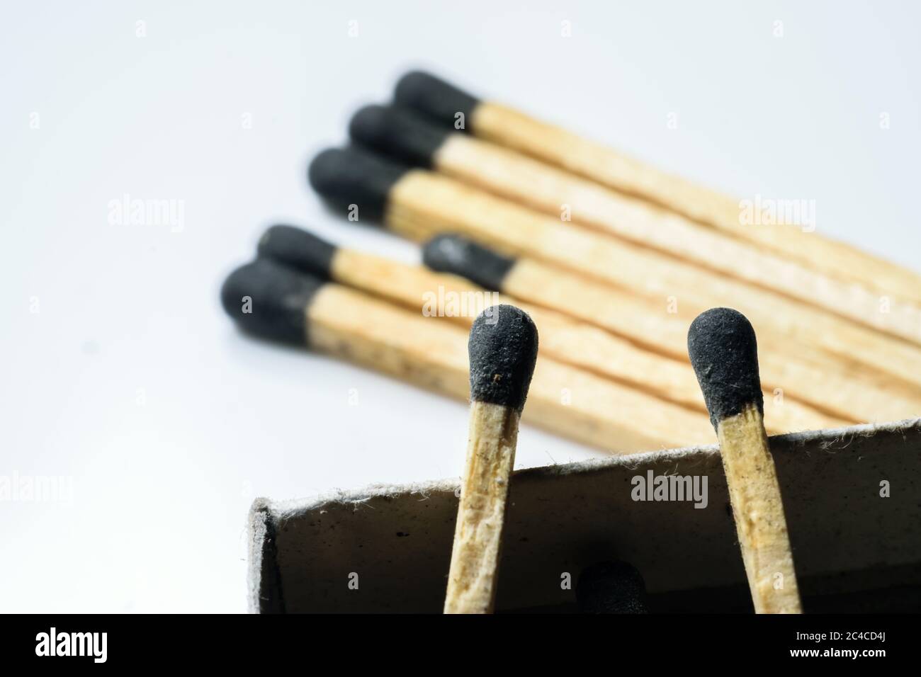 Two match sticks in focus over the edge of a match box and multiple ...
