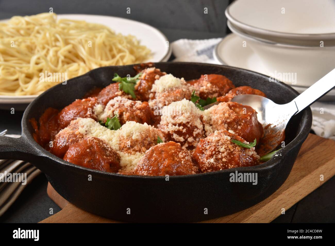 Spaghetti sauce with meatballs in a cast iron skillet with a plate of ...