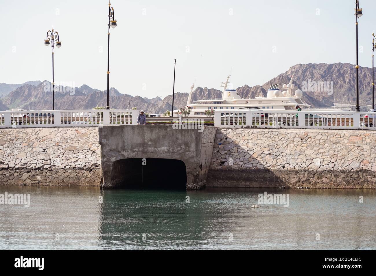 Muscat / Oman - February 15, 2020: Muslim man fishing over bridge with ...
