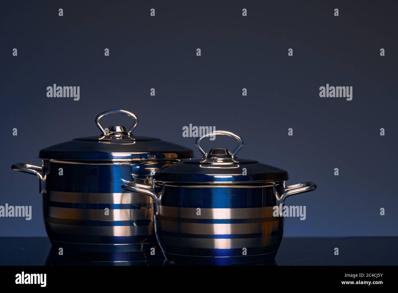 New cookware on black background, front view Stock Photo - Alamy