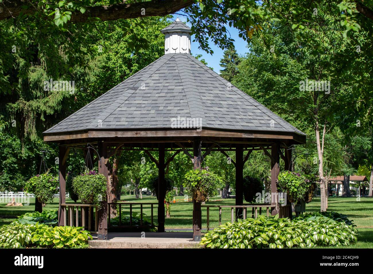 Nicely landscaped wooden gazebo pavilion in a scenic park location ...