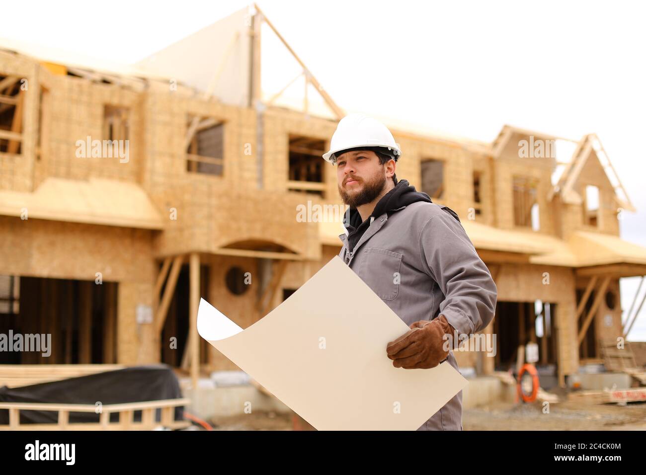 Engineer holding architecture drawing plan on paper at construction ...