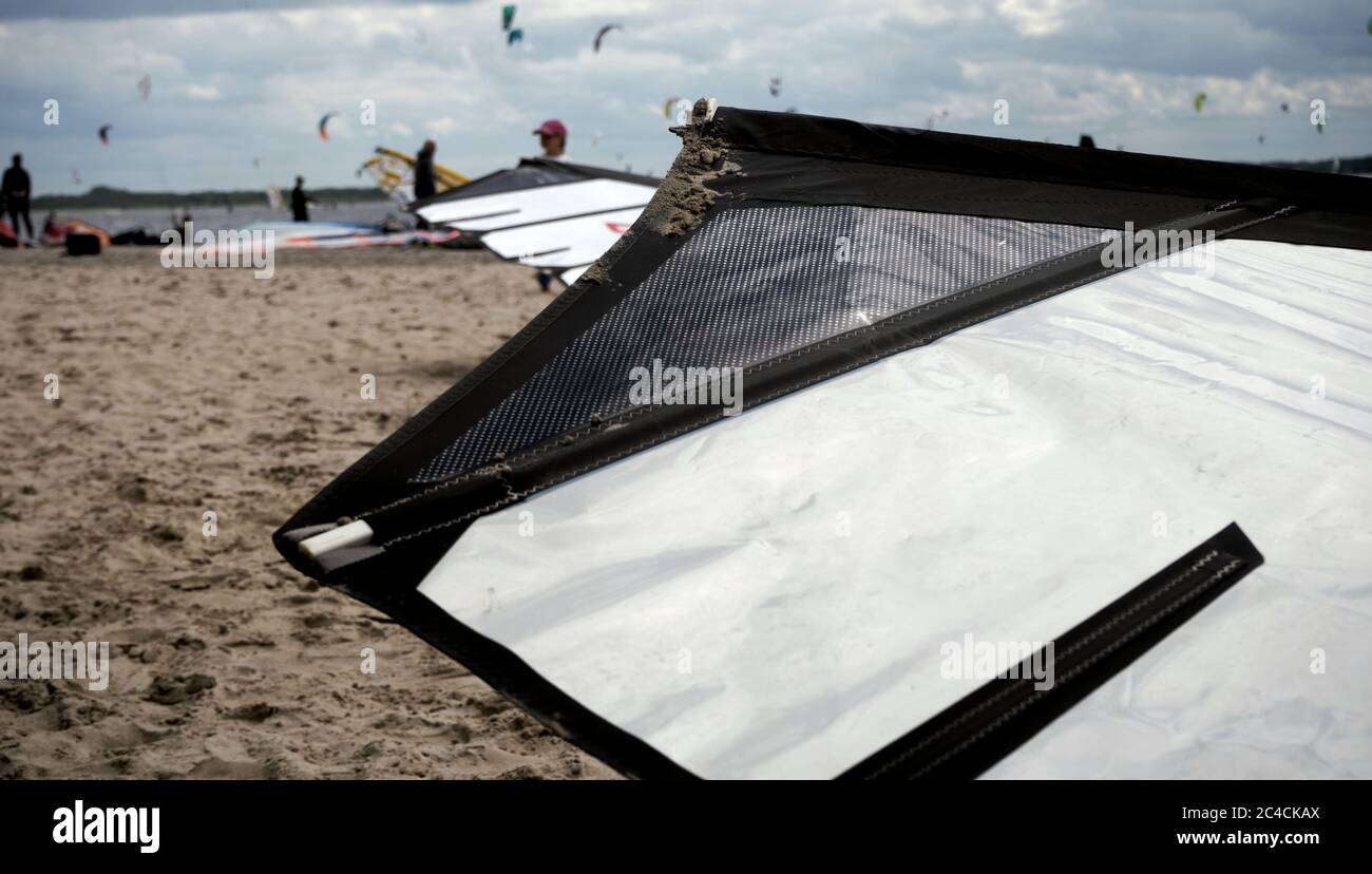 Black and white sail of a windsurf board on the beach, blurred ...