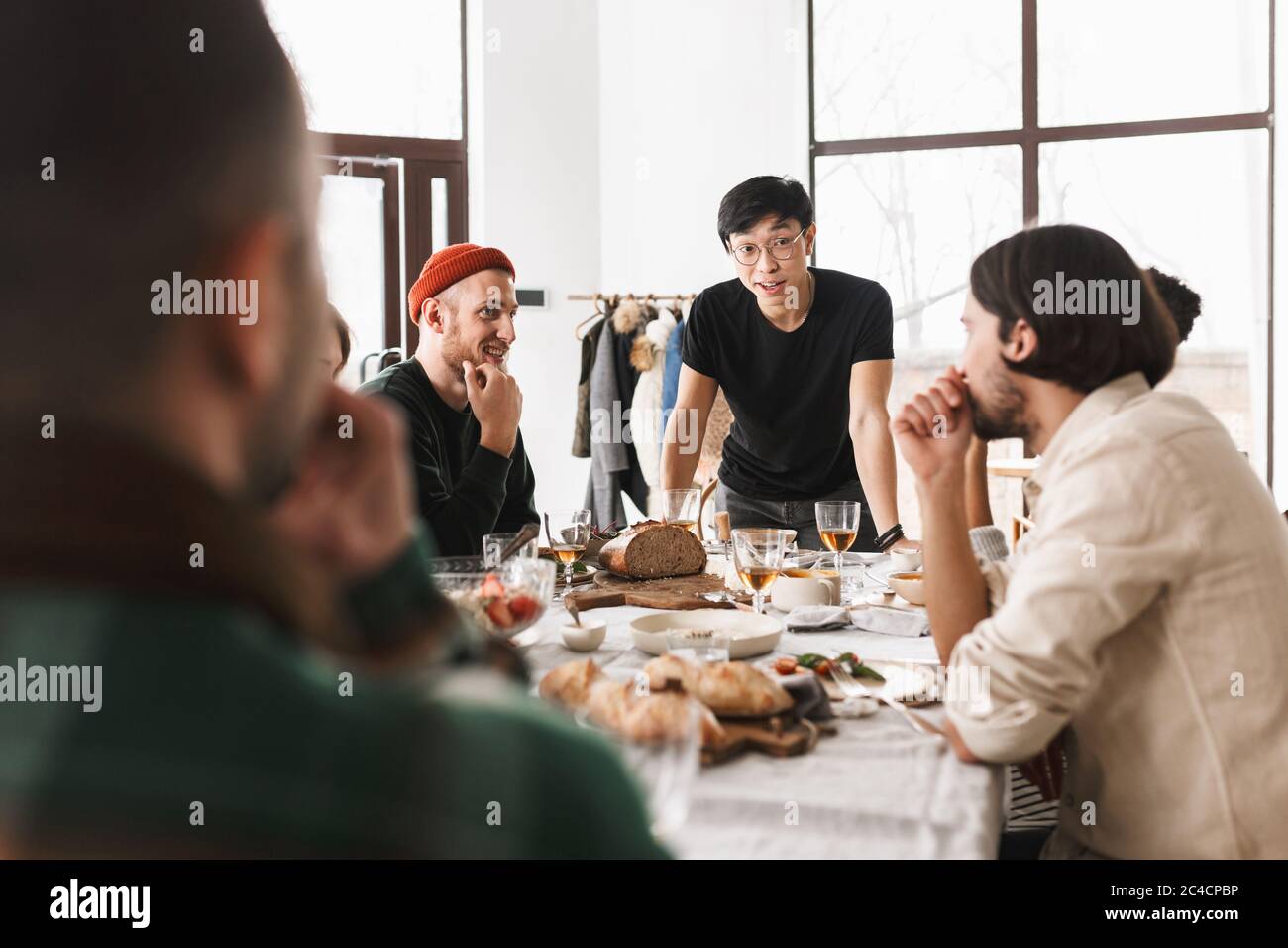 Young asian man in eyeglasses and black T-shirt leaning on table ...