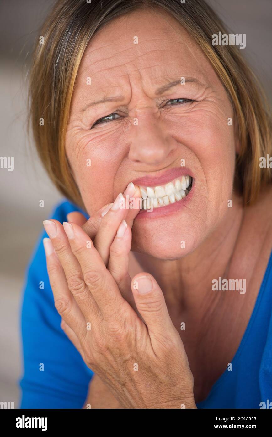 Portrait attractive mature woman with tooth ache, in pain, stressed ...