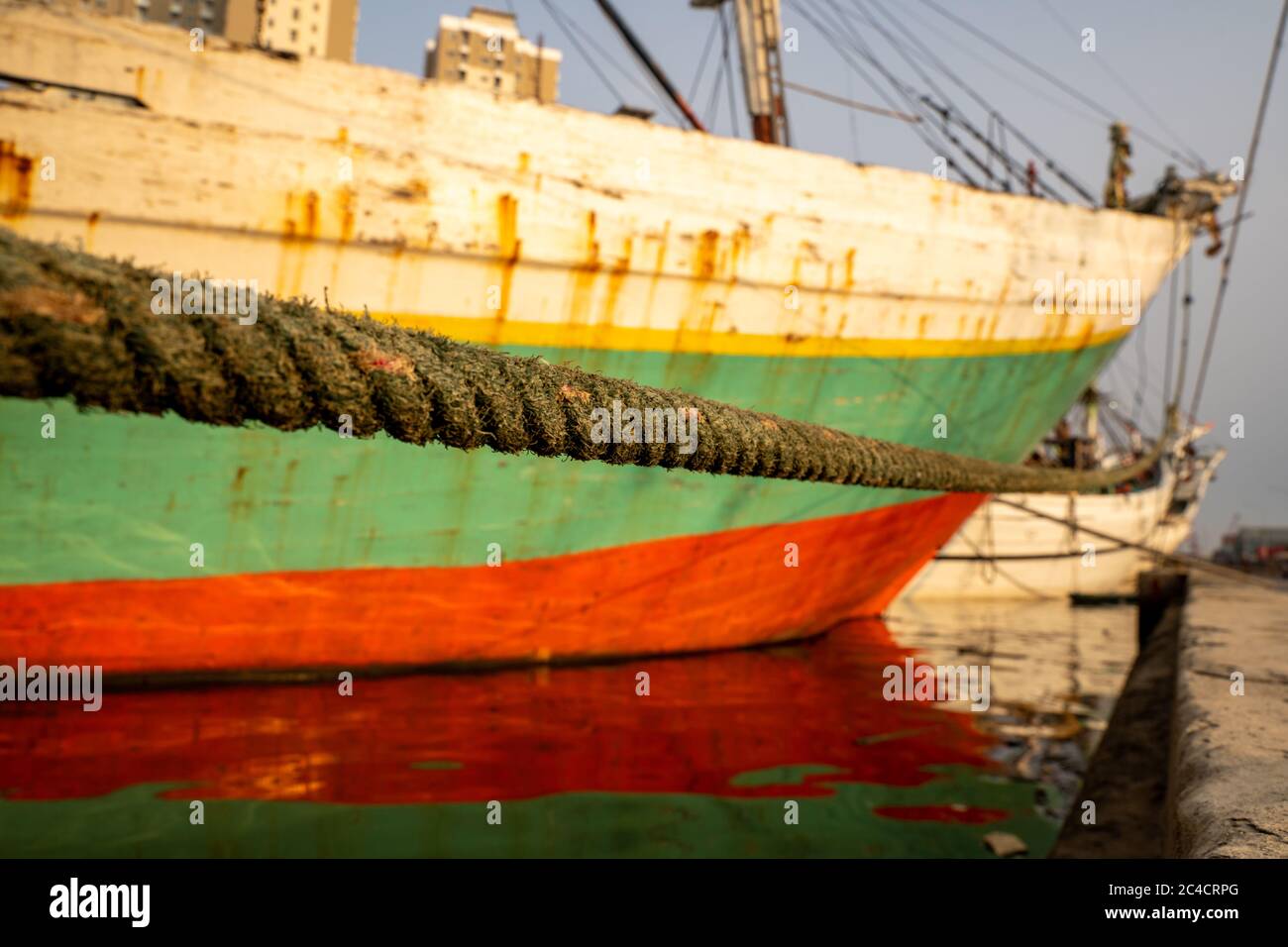 A detailed shot of a rope used to keep a ship secured in a busy Jakarta ...