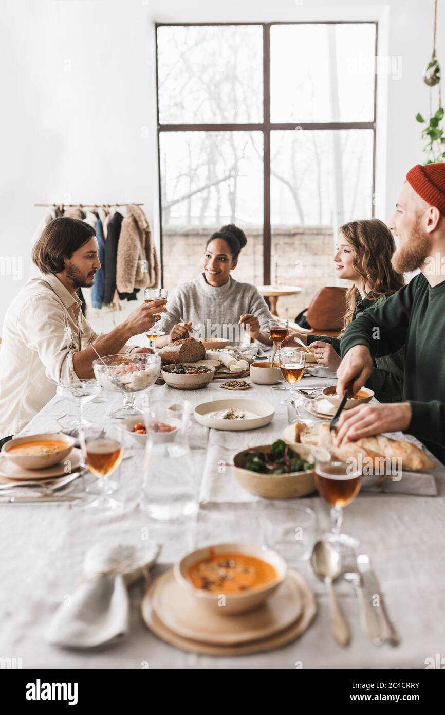 Group of beautiful international friends sitting at the table full of ...