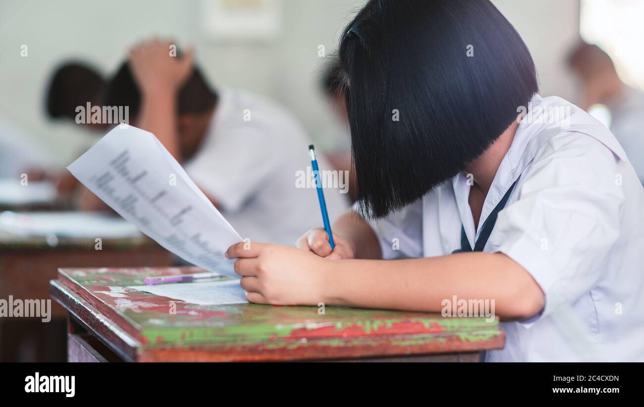Students taking exam answer sheets exercises in classroom of school ...