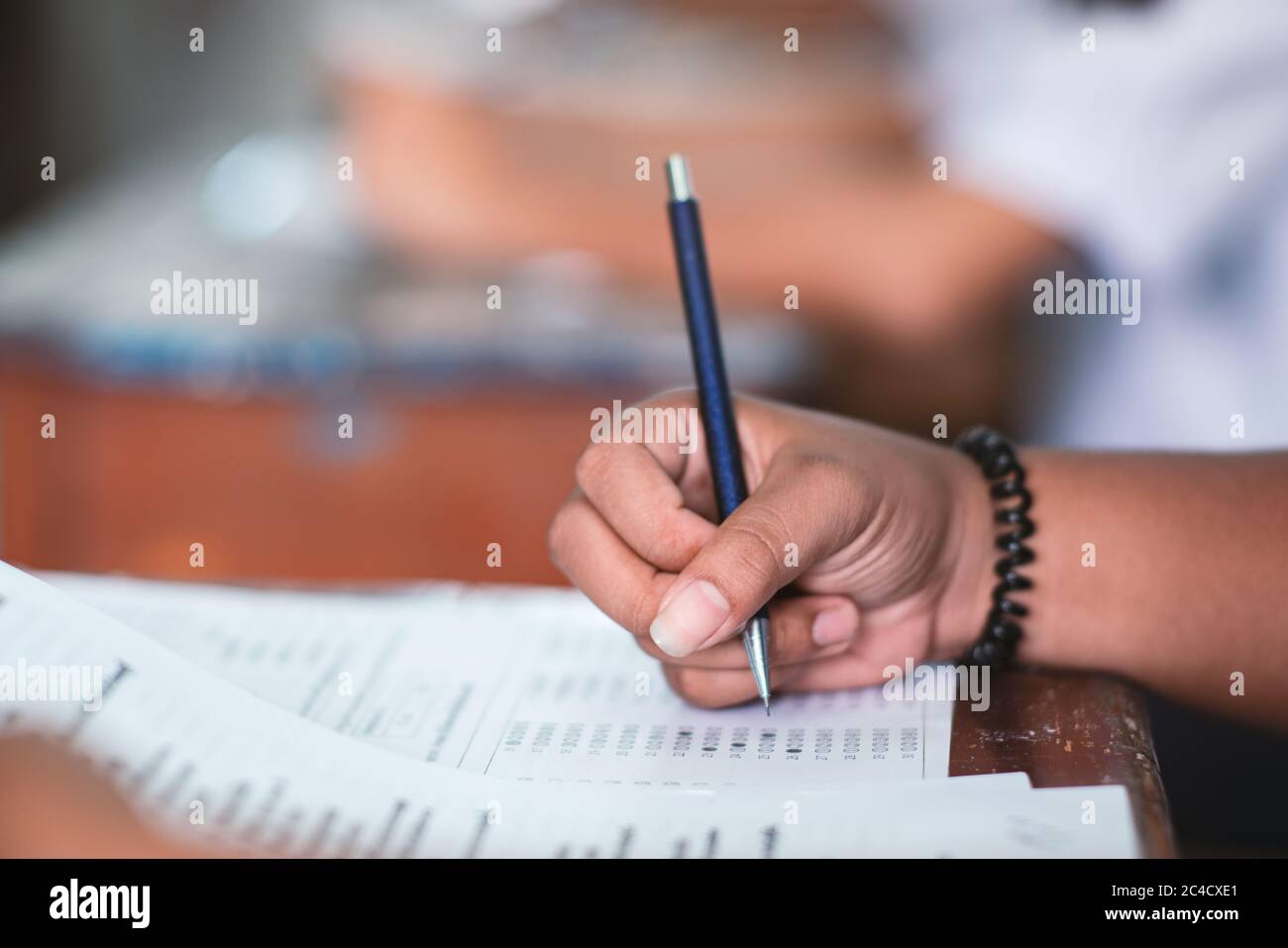 Students taking exam answer sheets exercises in classroom of school ...