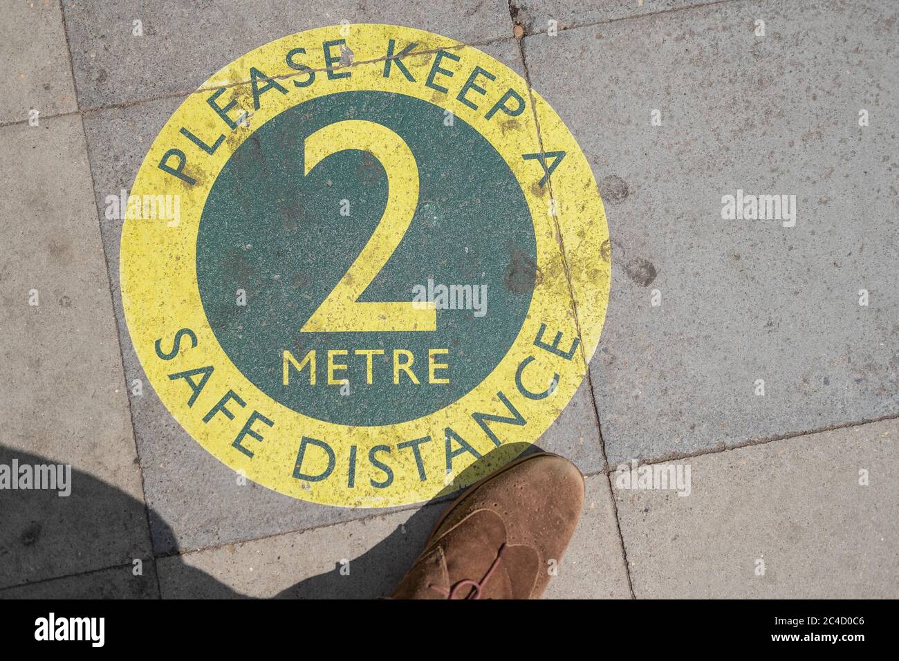 Concept of a 2 Metre social distancing sign seen on a pavement. Used to ...