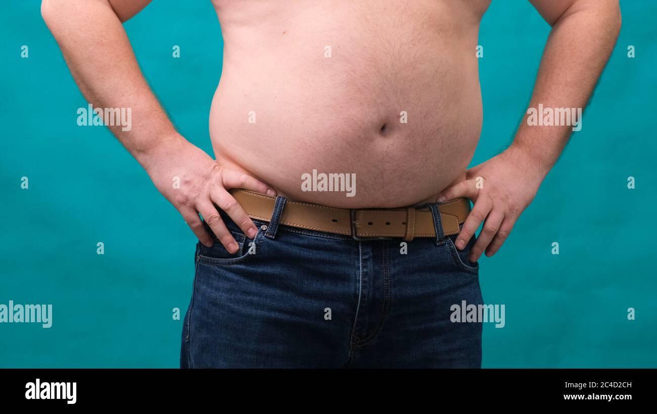male with a big belly shows his fat on a green screen. The concept of ...