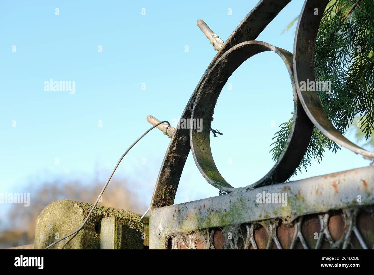 Wrought iron garden gate showing improvised spikes welded to the ornate ...