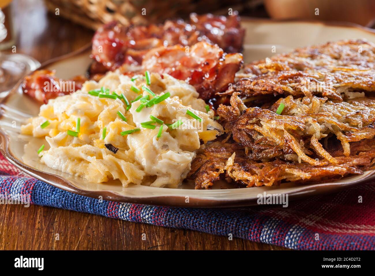 Hash browns. Potato pancakes with crispy fried bacon and scrambled eggs ...