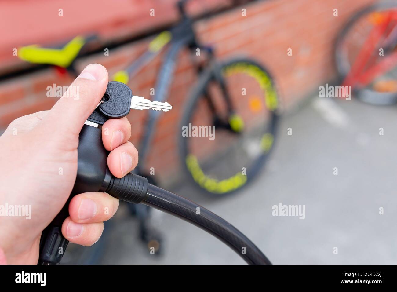 security and safety concept, key lock on bicycle wheel in parking ...