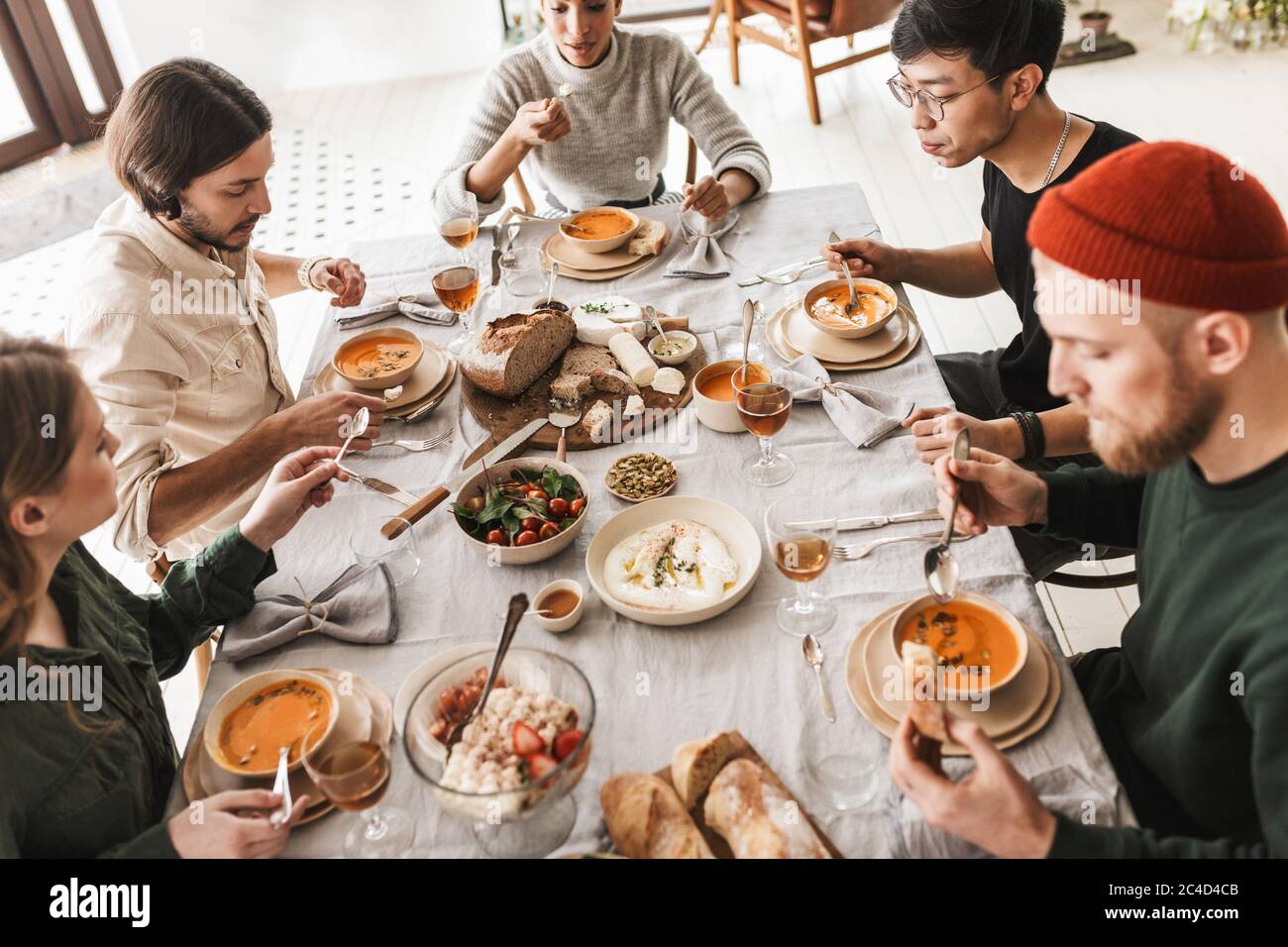 Top view of attractive international friends sitting at the table full ...