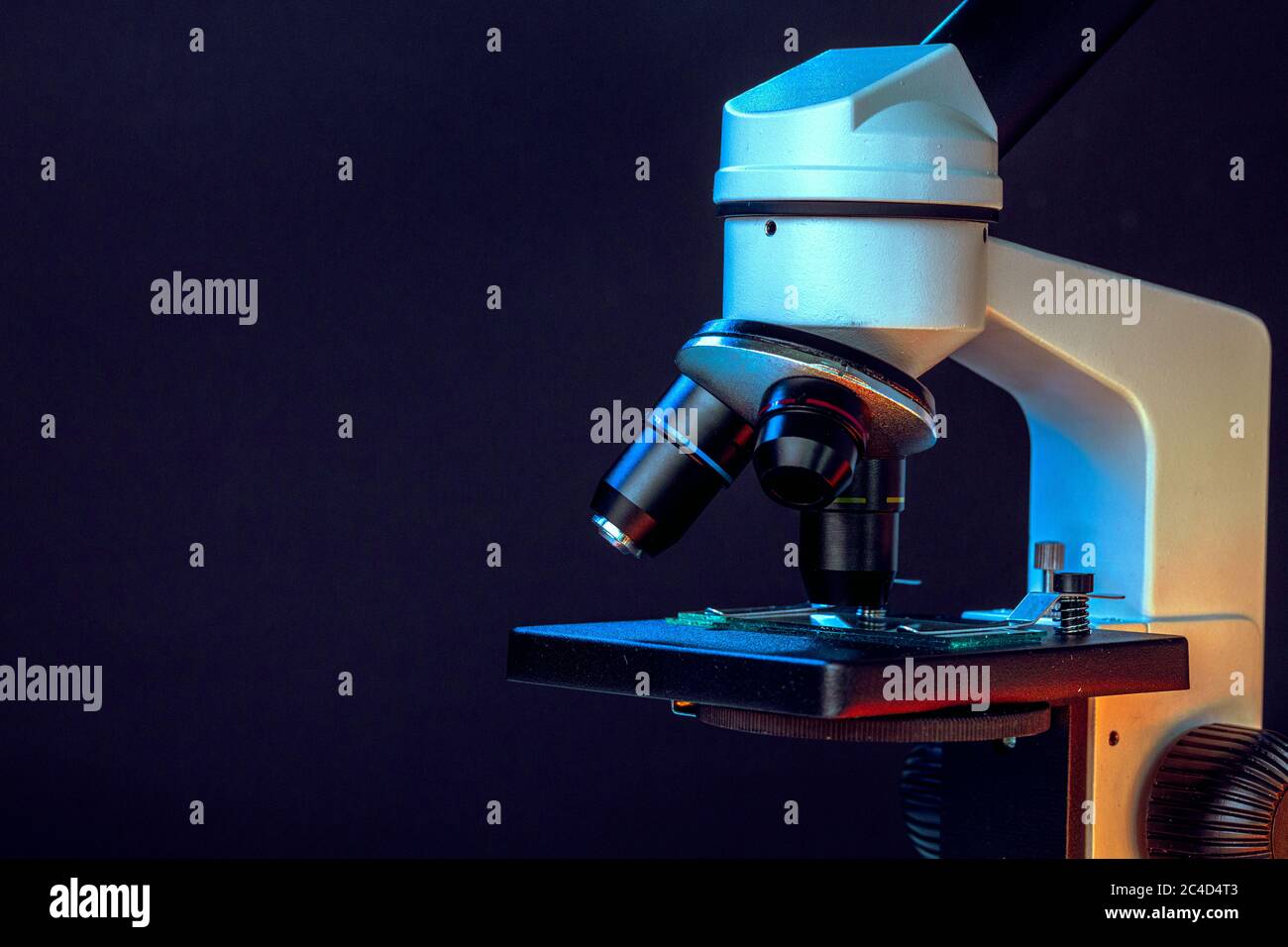 Microscope with lenses close up against dark background Stock Photo - Alamy