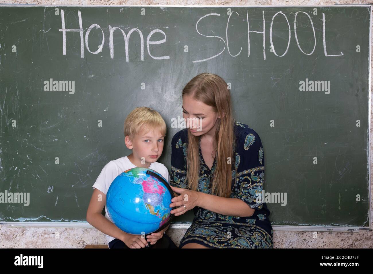 Mother is studying a world map on a globe with her son Stock Photo - Alamy