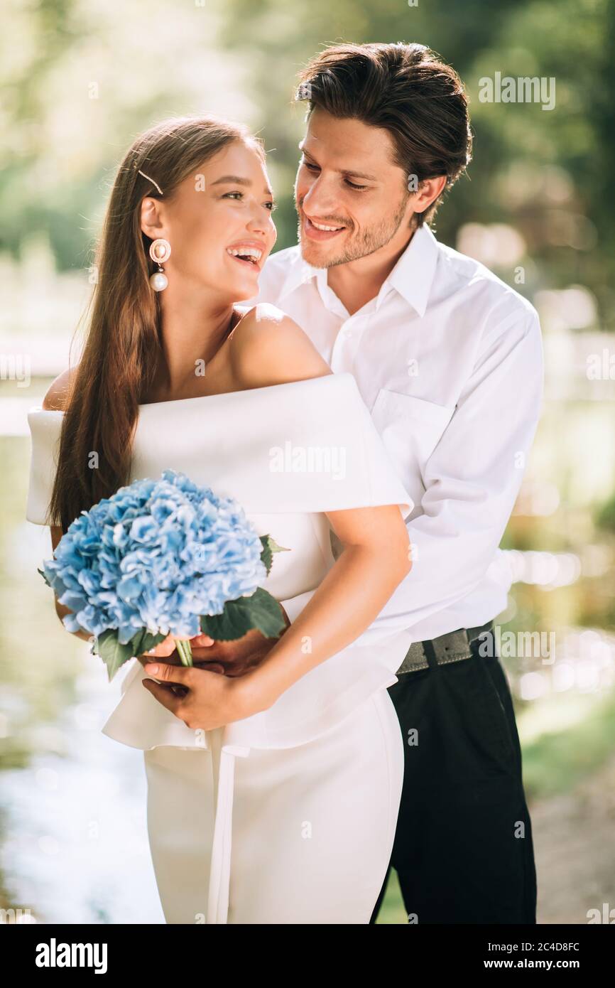Affectionate Bride And Groom Hugging In Park During Wedding Ceremony ...