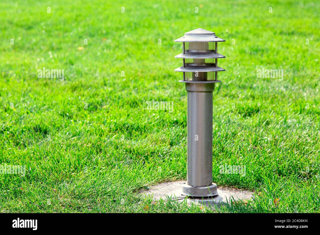 Ground iron streetlight electric lamp with bulb on green lawn with ...