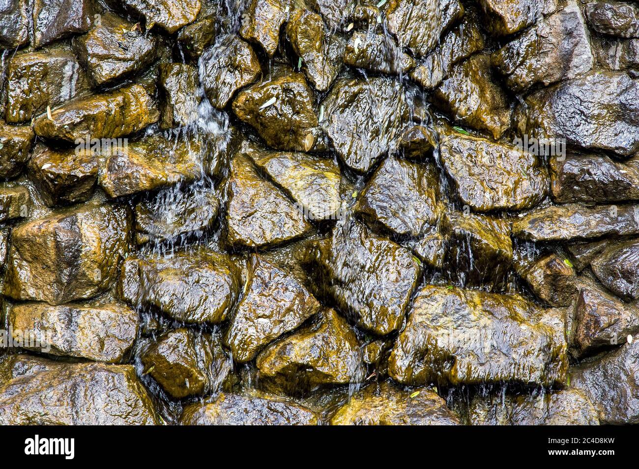 artificial waterfall from a pile of stone water flowing down it, close ...