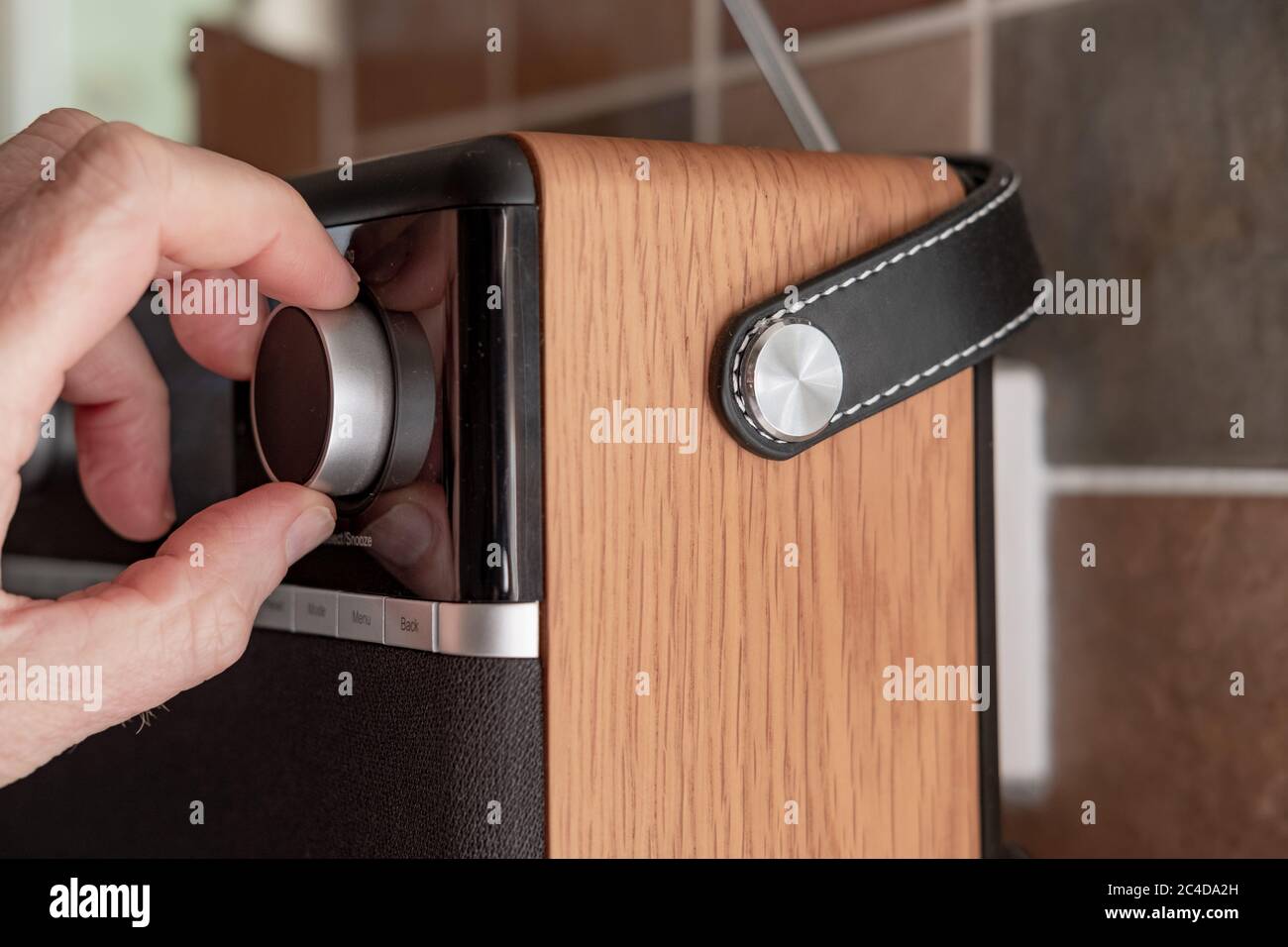 Person seen tuning a digital streaming radio in a kitchen area. The ...
