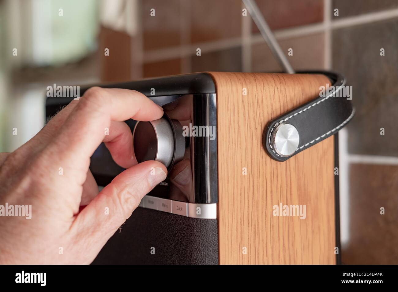 Person seen tuning a digital streaming radio in a kitchen area. The ...