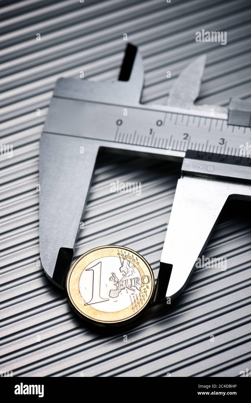 metal gauge measuring a one euro coin on a metal surface Stock Photo ...