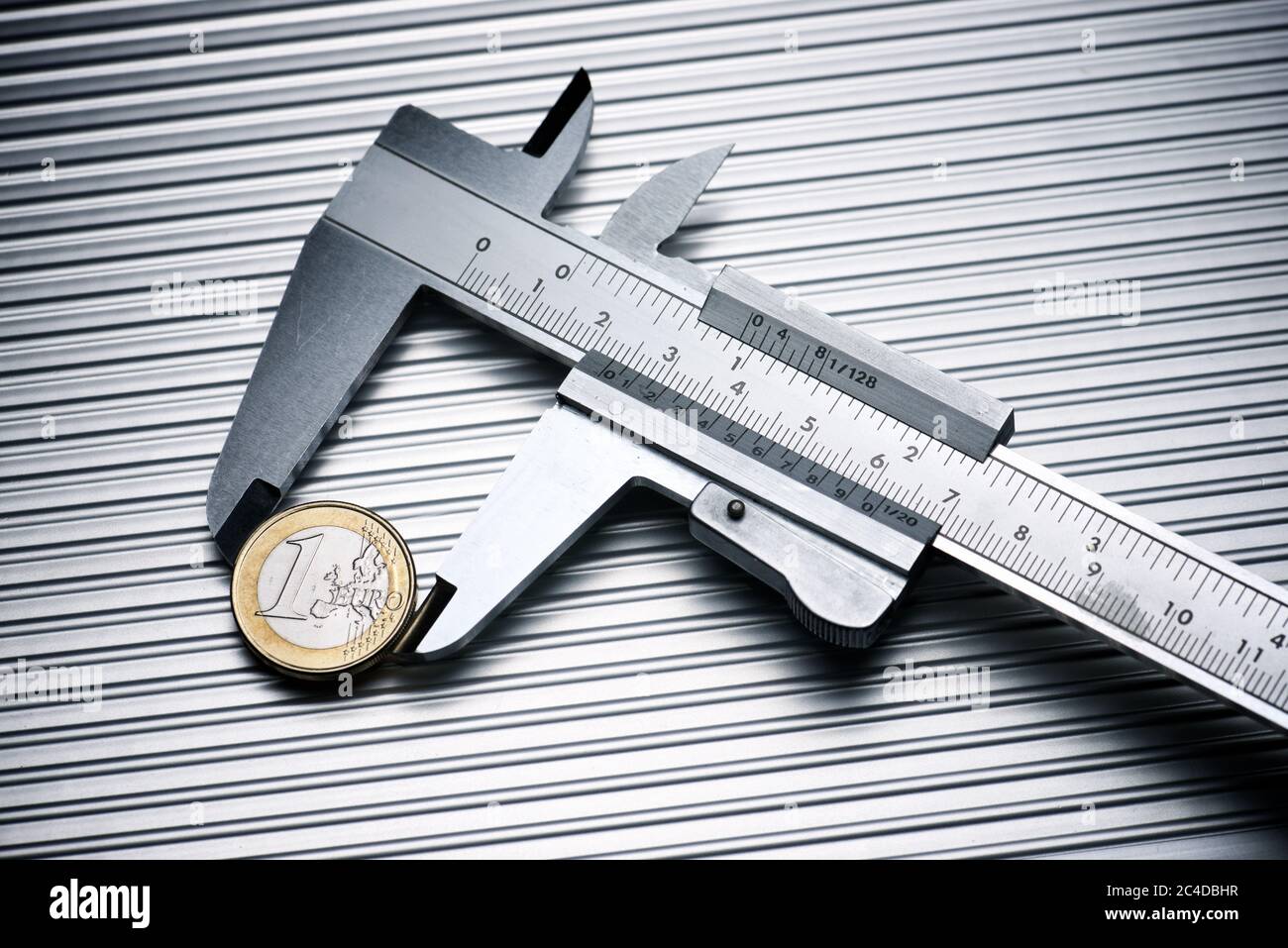 metal gauge measuring a one euro coin on a metal surface Stock Photo ...