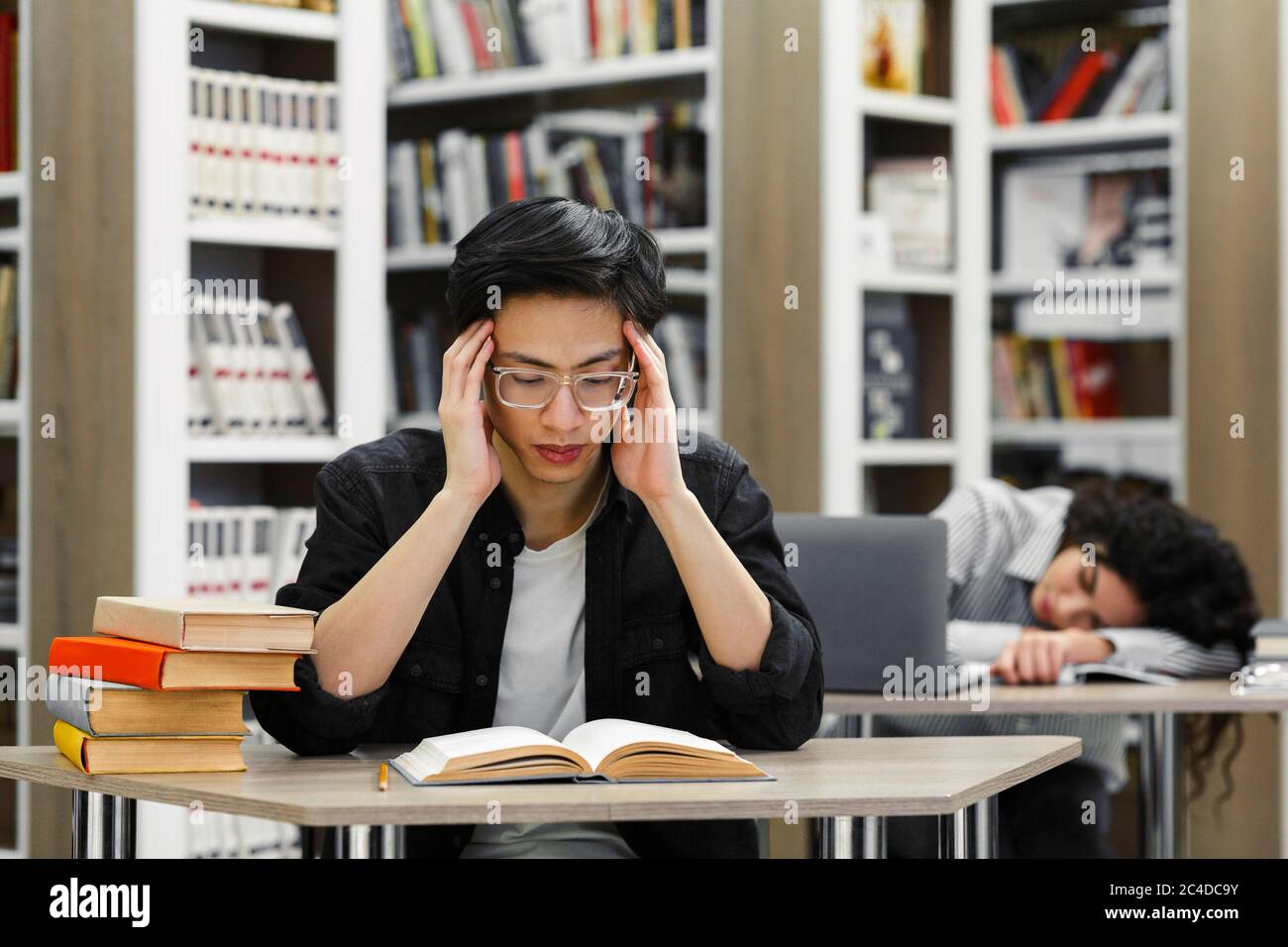 Two tired students studying in the university library Stock Photo - Alamy