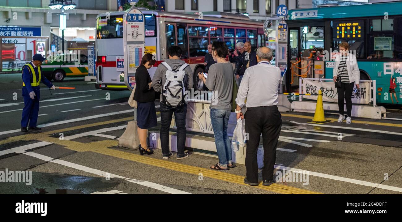 Commuters lining up waiting for a bus at Shibuya station, Tokyo, Japan ...