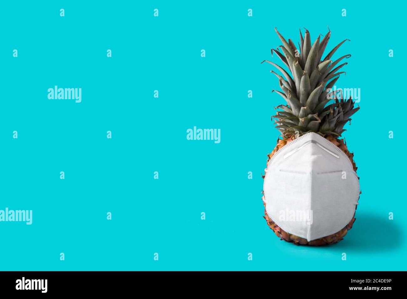 Pineapple with protective face mask on blue background Stock Photo - Alamy