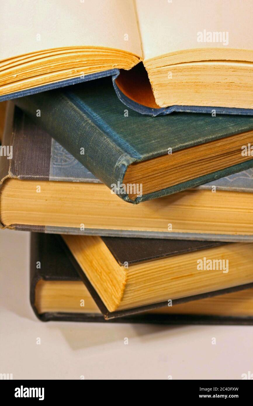 Vertical shot of a stack of old books on a white surface Stock Photo ...