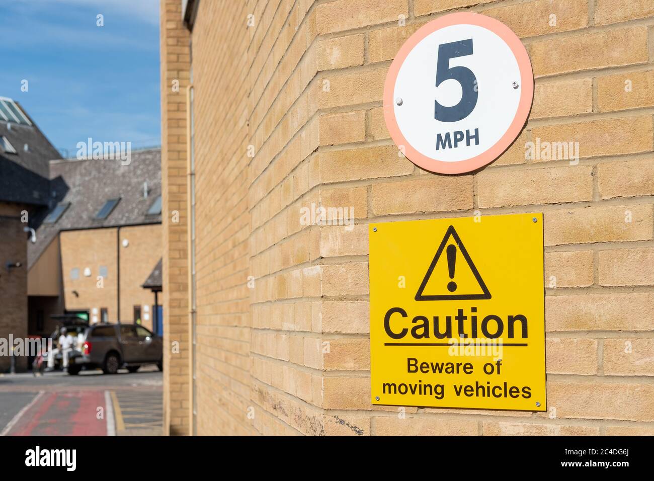 Shallow focus of a 5 MPH and caution sign seen at the back of a retail ...