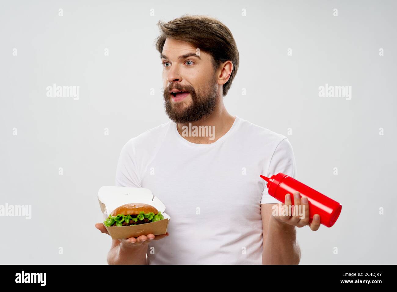 Young man with a juicy hamburger a man eating a burger Stock Photo - Alamy