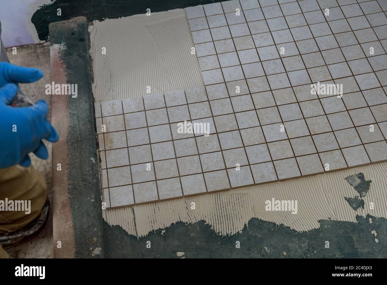 Plaster repair work laying tile, trowel in a man hand Stock Photo - Alamy