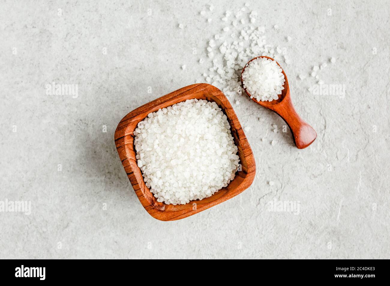 Salt in wooden bowl with scoop on gray stone table. Sea salt flat lay ...