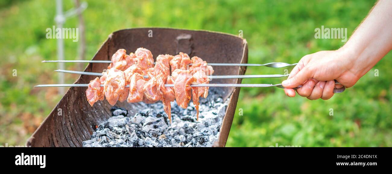 Hands of man prepares barbecue meat on skewer by grill on fire outdoors Stock Photo - Alamy