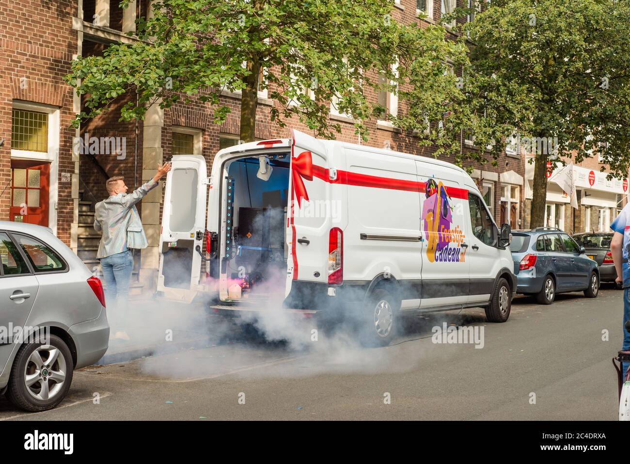 A man with a saxophone outside his party van on the street in The Hague ...