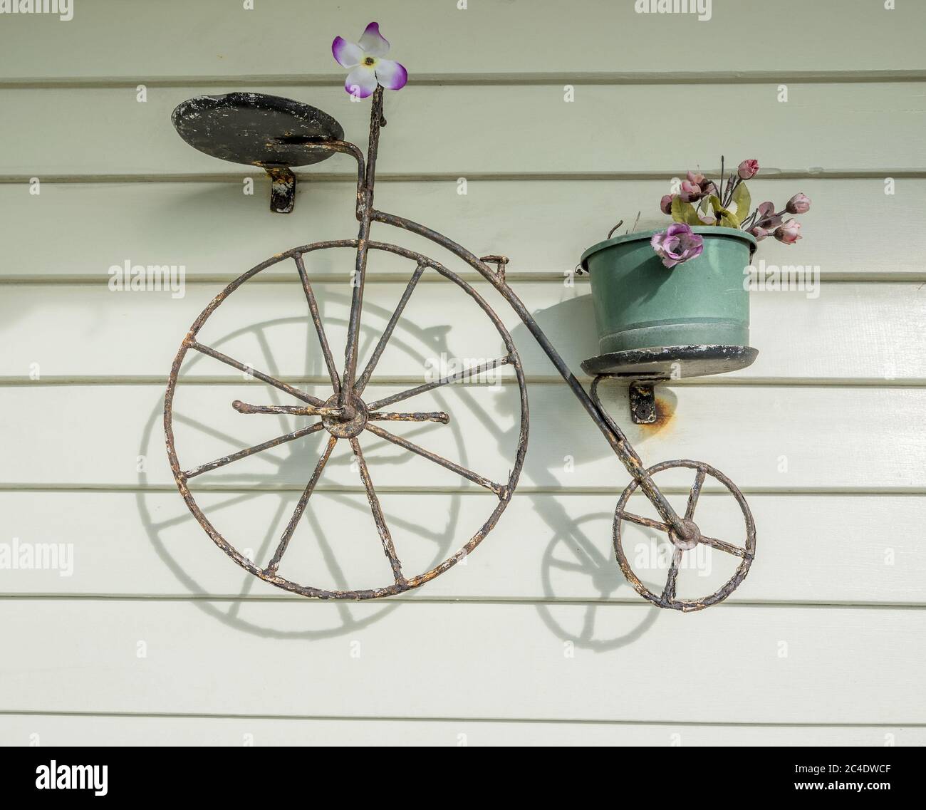 Closeup shot of an old-fashioned bicycle decoration on a wall with a ...
