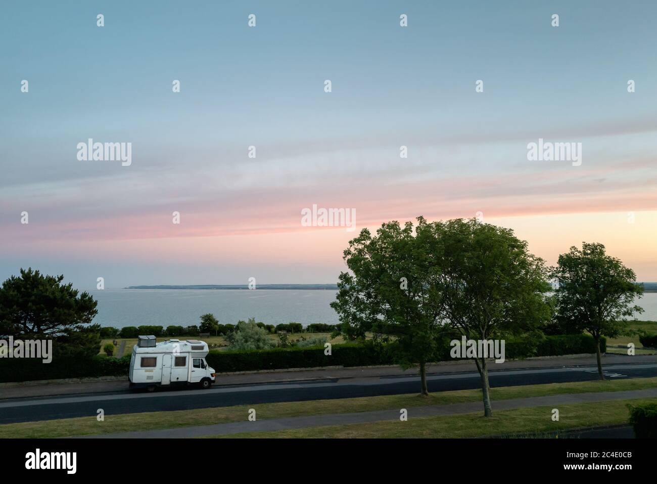 A vintage style camper van, motorhome with a metal trunk attached to ...