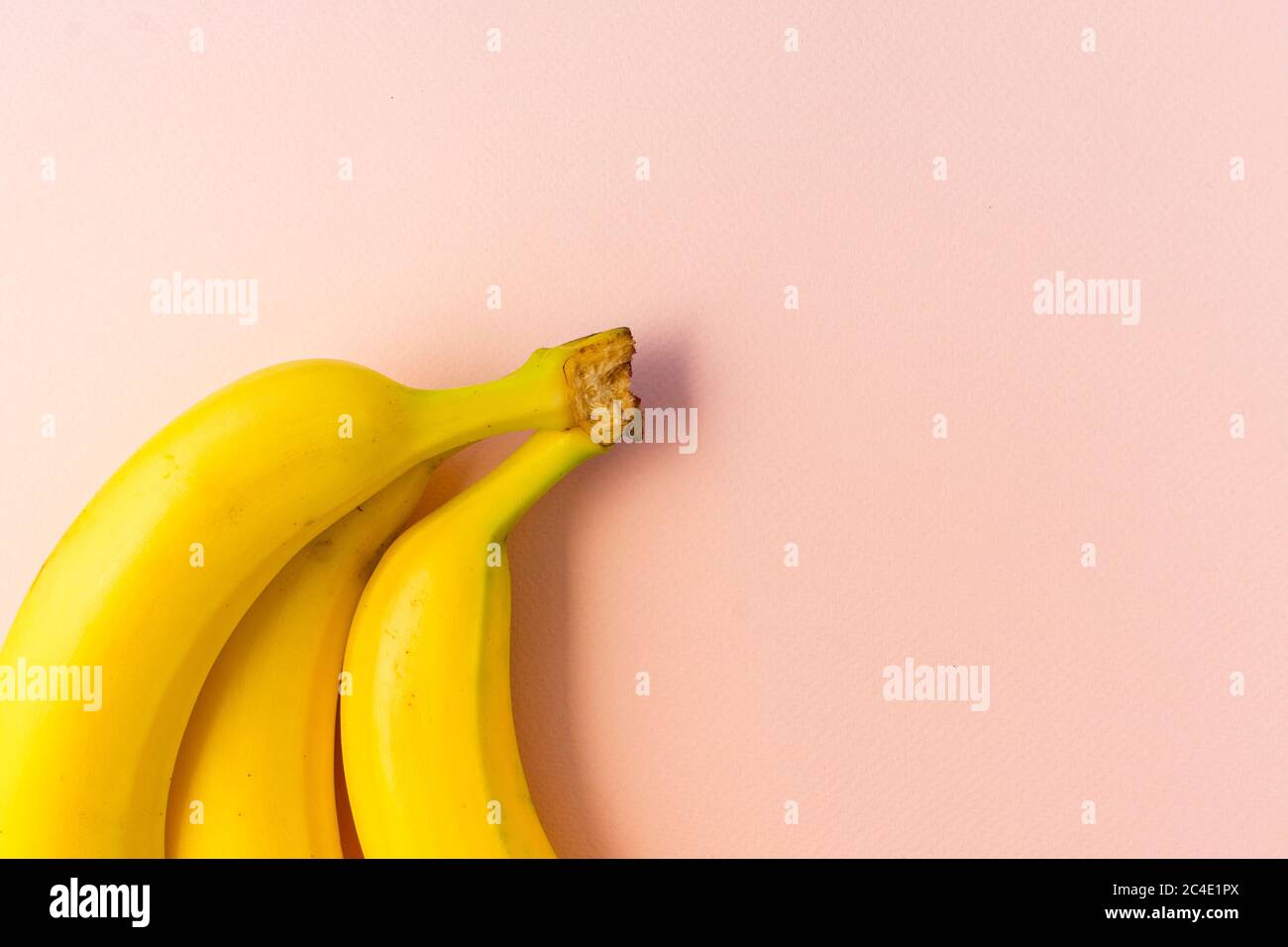 Yellow Bunch Of Ripe Bananas On A Pink Paper Background Copyspace