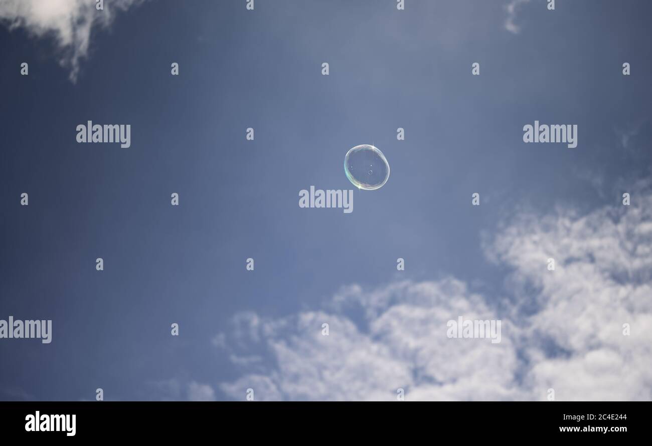 Small soap bubble floating in the air against the blue sky Stock Photo ...