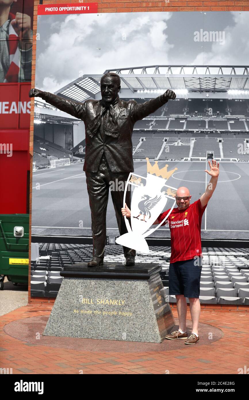 Liverpool fan Paul Davis poses for a photo with the Bill Shankly statue ...