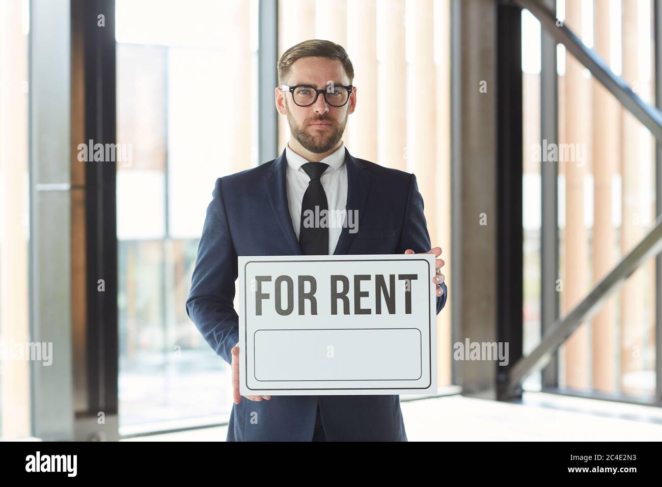 Portrait of mature businessman in suit holding placard For Rent and ...