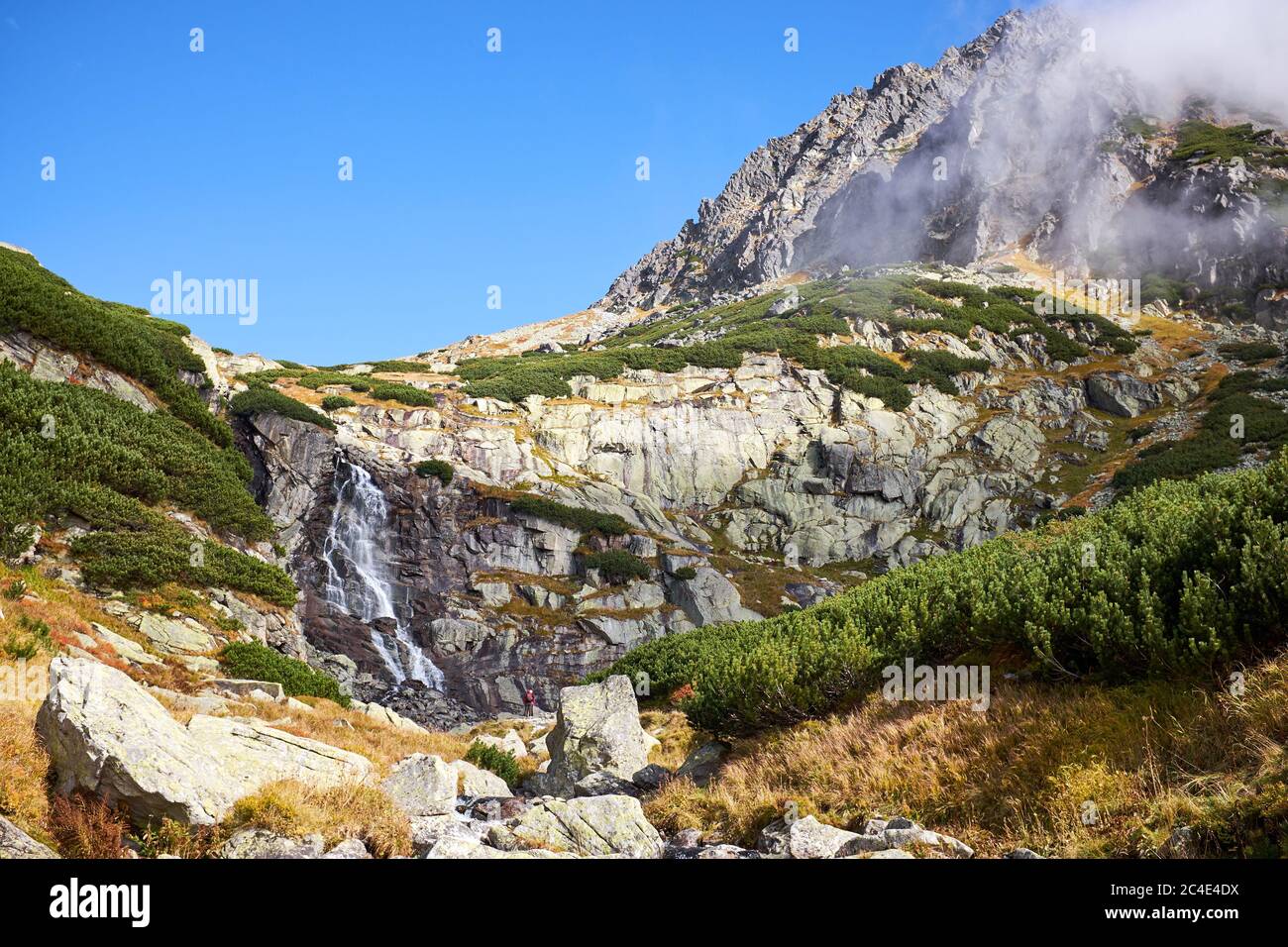 The Skok waterfall with the mountain and clouds at the yellow hiking ...
