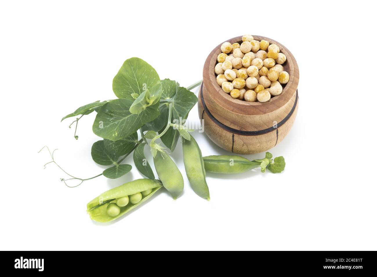 Dried peas in a wooden barrel and fresh plant with pods isolated on a ...